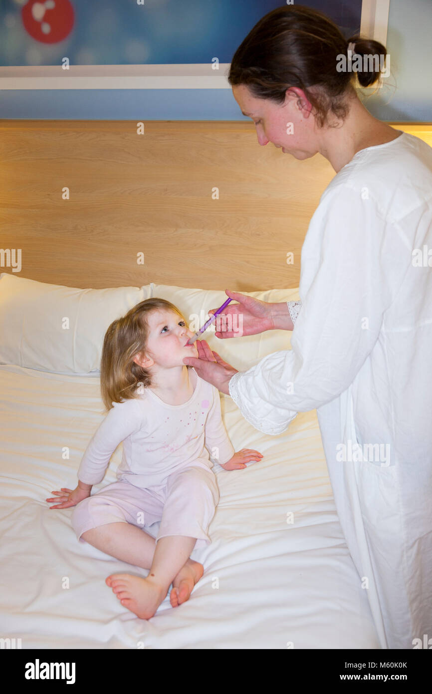 Holiday illness : mother / mum / mom giving Calpol medicine with ...