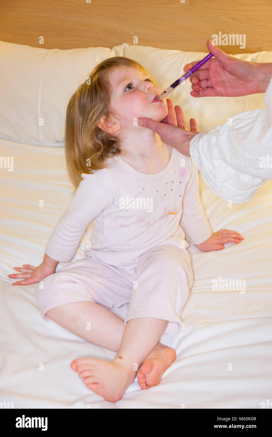 Mother / mum / mom giving Calpol medicine with paracetamol to – an ...