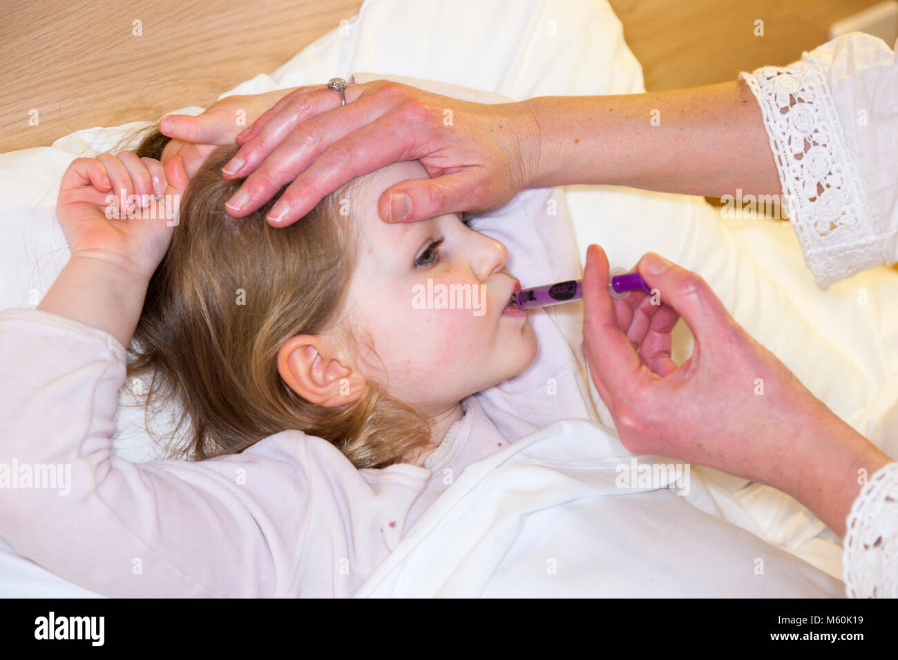 Mother / mum / mom giving Calpol medicine with paracetamol to – an ...