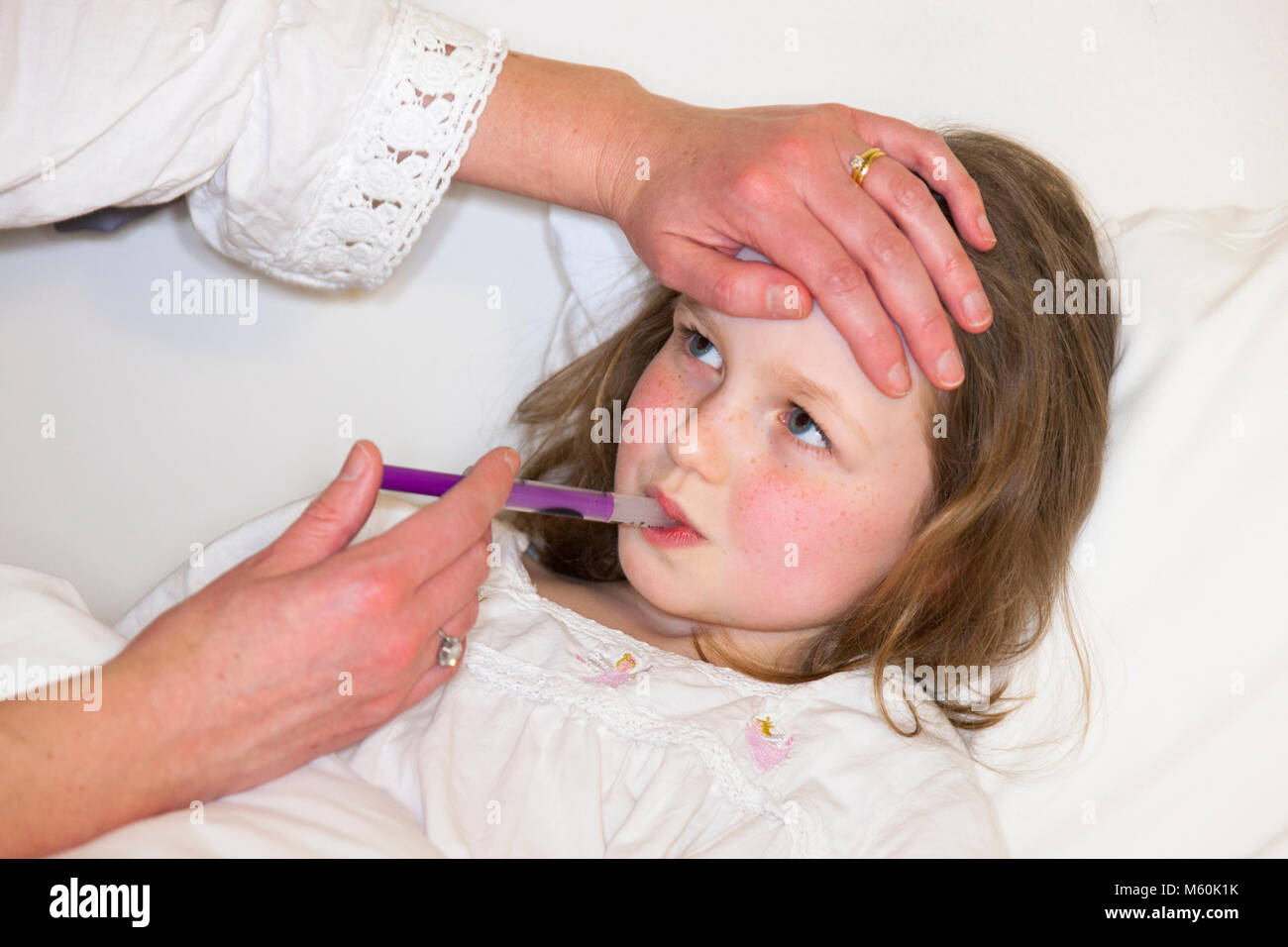 Mother / mum / mom giving Calpol medicine with paracetamol to – an ...