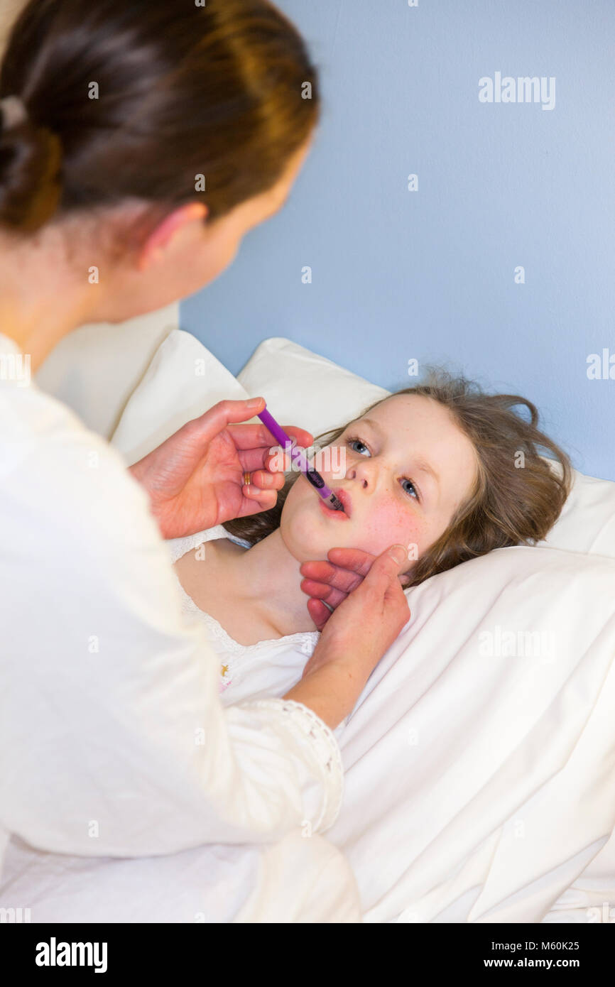 Mother / mum / mom giving Calpol medicine with paracetamol to – an ...