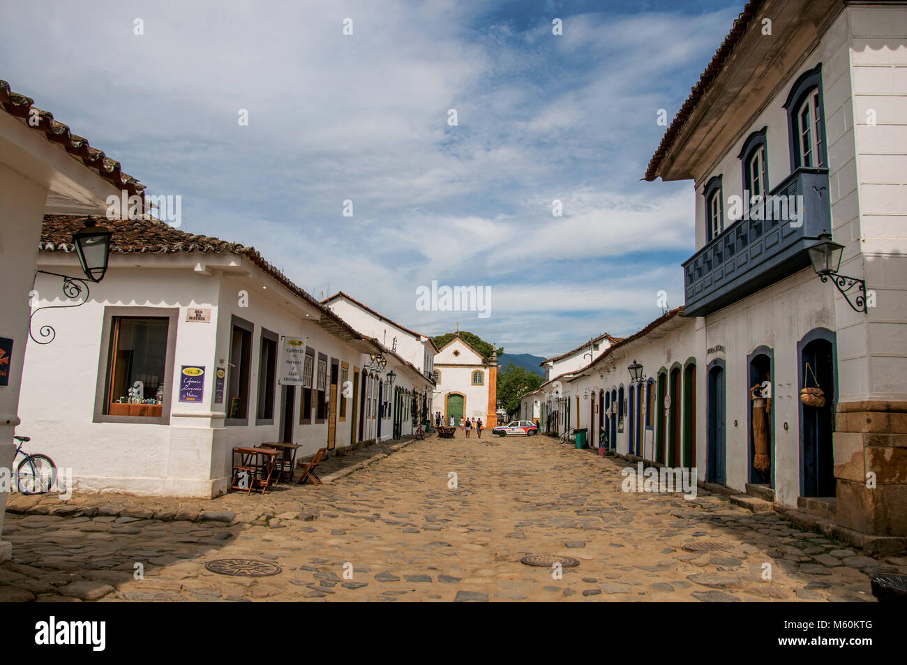 Paraty, Brazil. Cobblestone street with old houses under blue cloudy ...