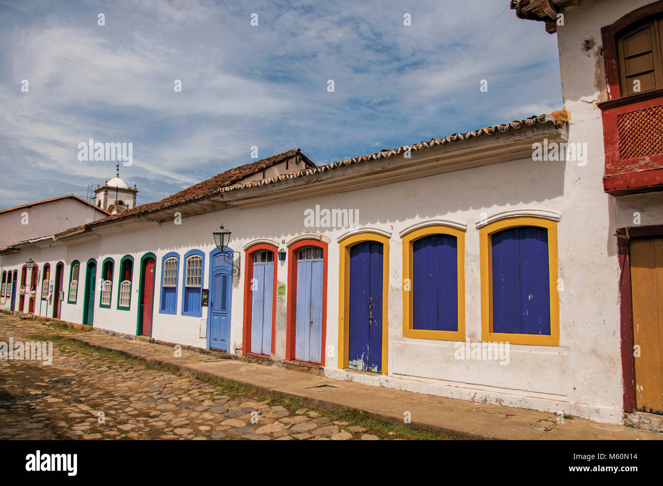 Paraty, Brazil. Cobblestone street with old houses under blue cloudy ...