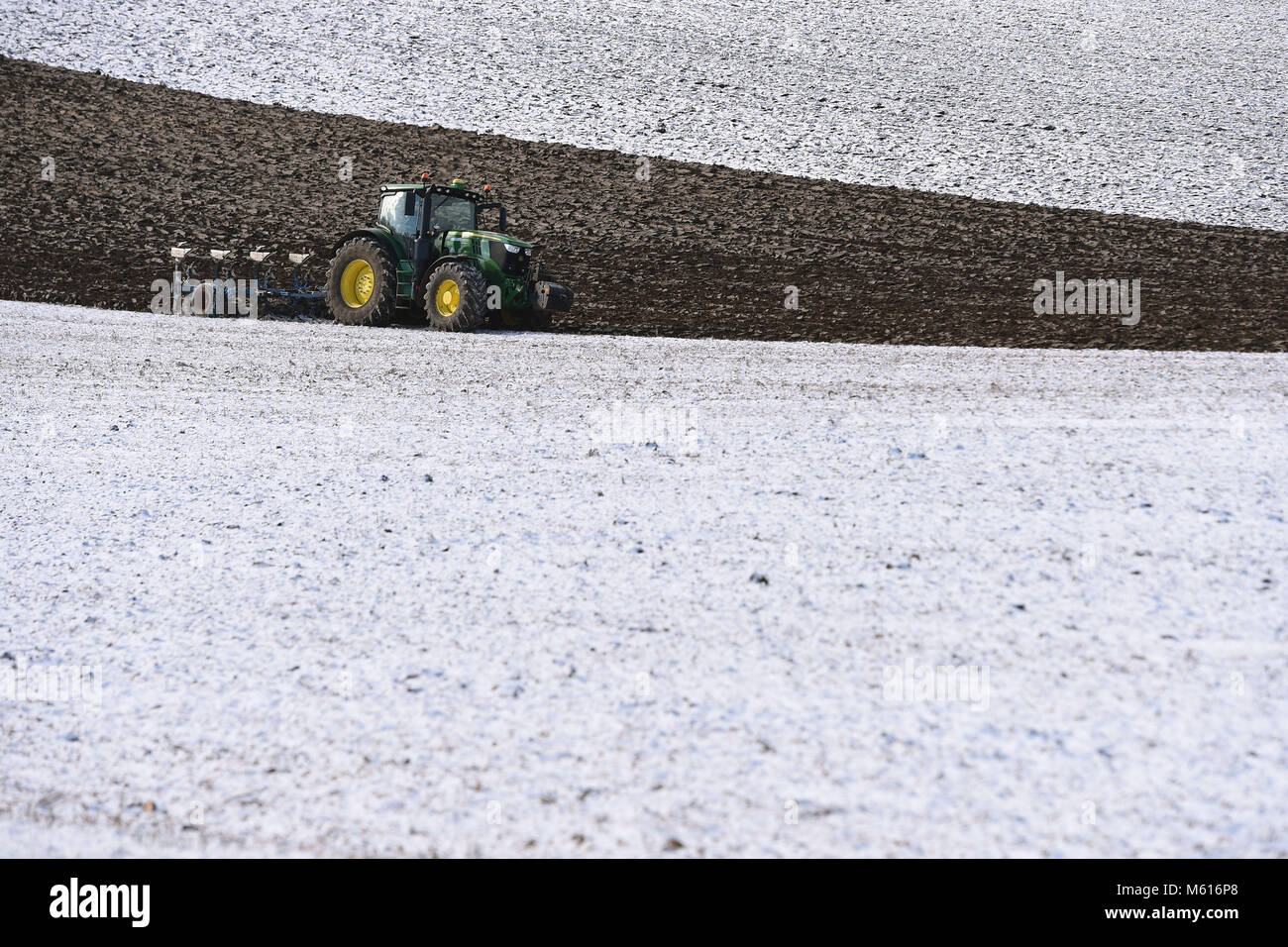 A farmer ploughs a snow covered field near Thetford in Norfolk ...