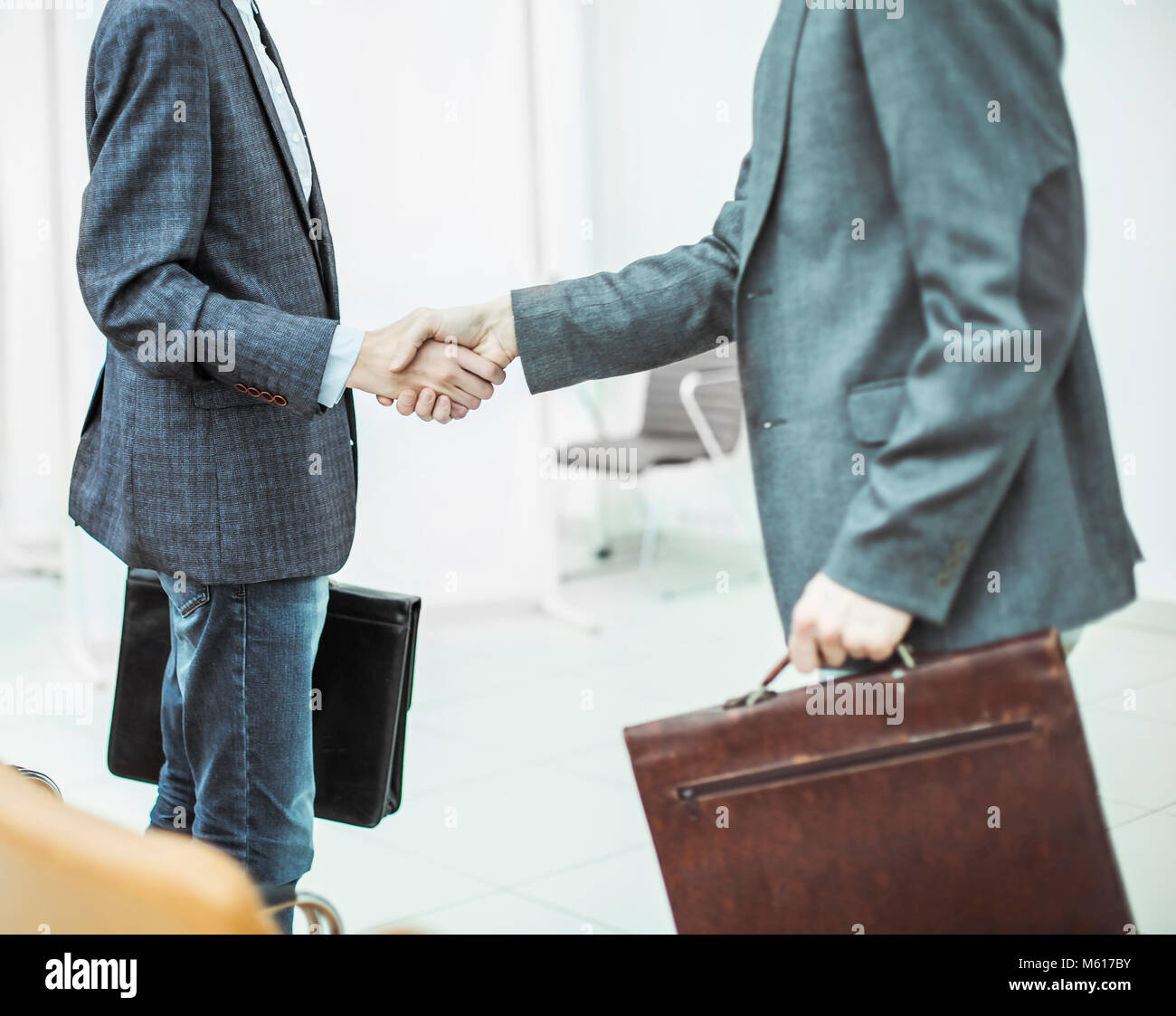 handshake between client and Manager on the background of the office ...