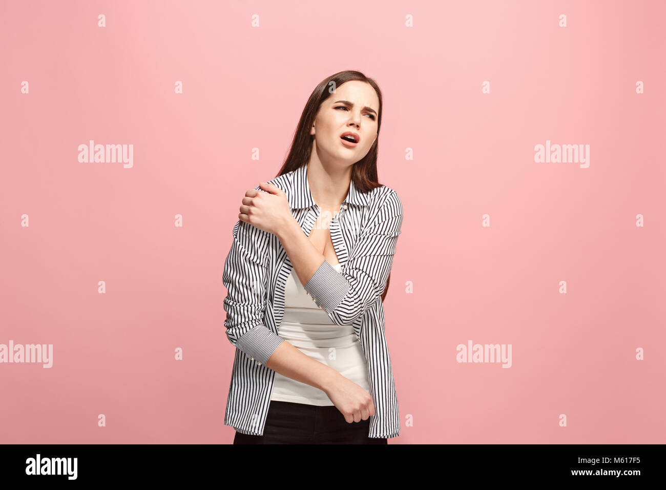 The shoulder ache. The sad woman with shoulder ache or pain on a pink ...