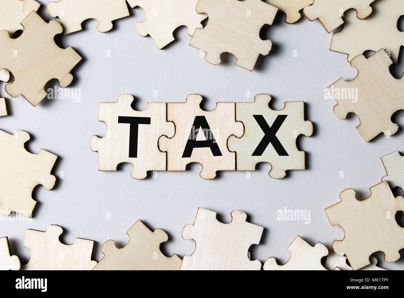Puzzle pieces with word tax Stock Photo - Alamy