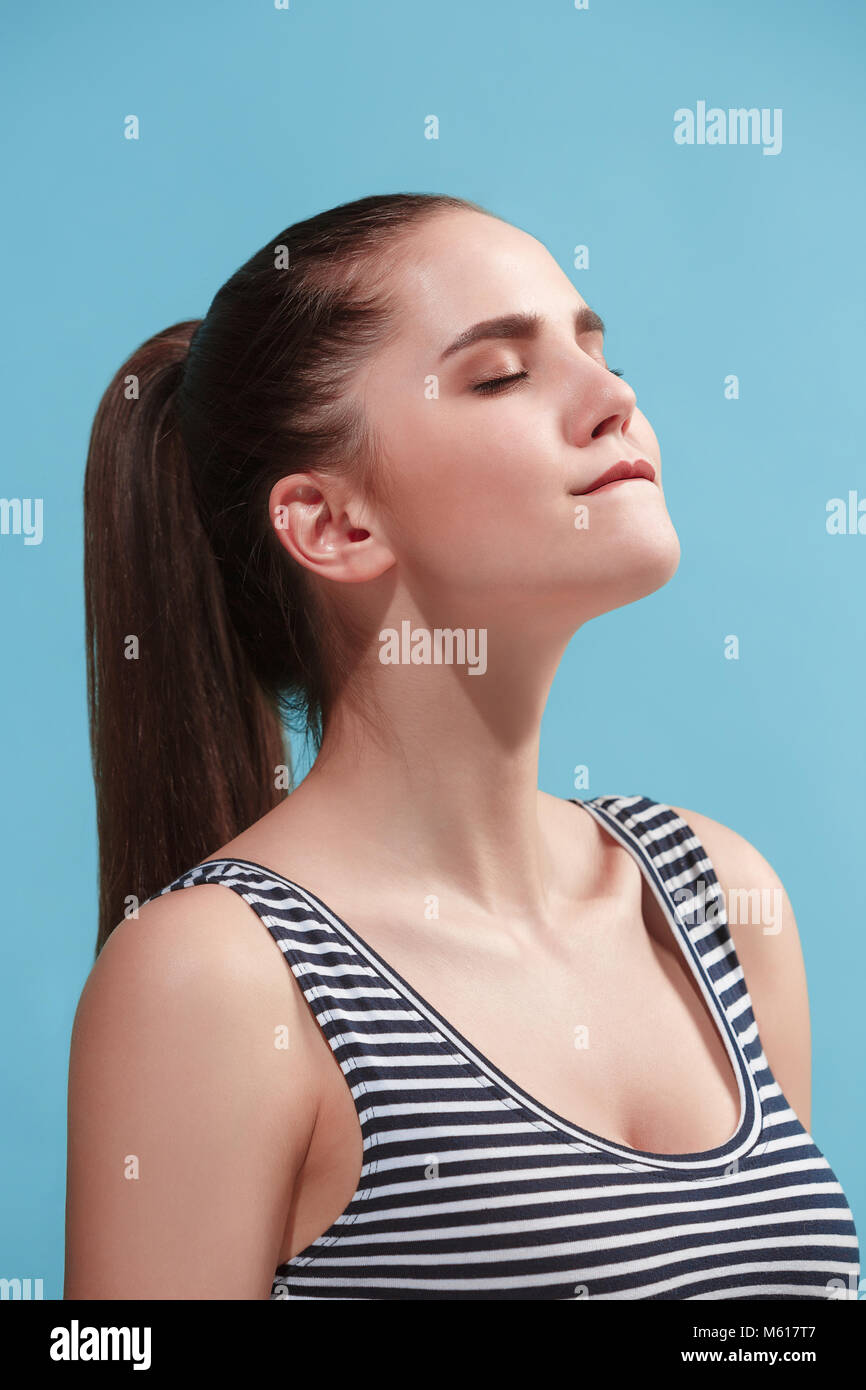 The young woman is looking satisfy on the blue background Stock Photo ... The young woman is looking satisfy on the blue background Stock Photo ...