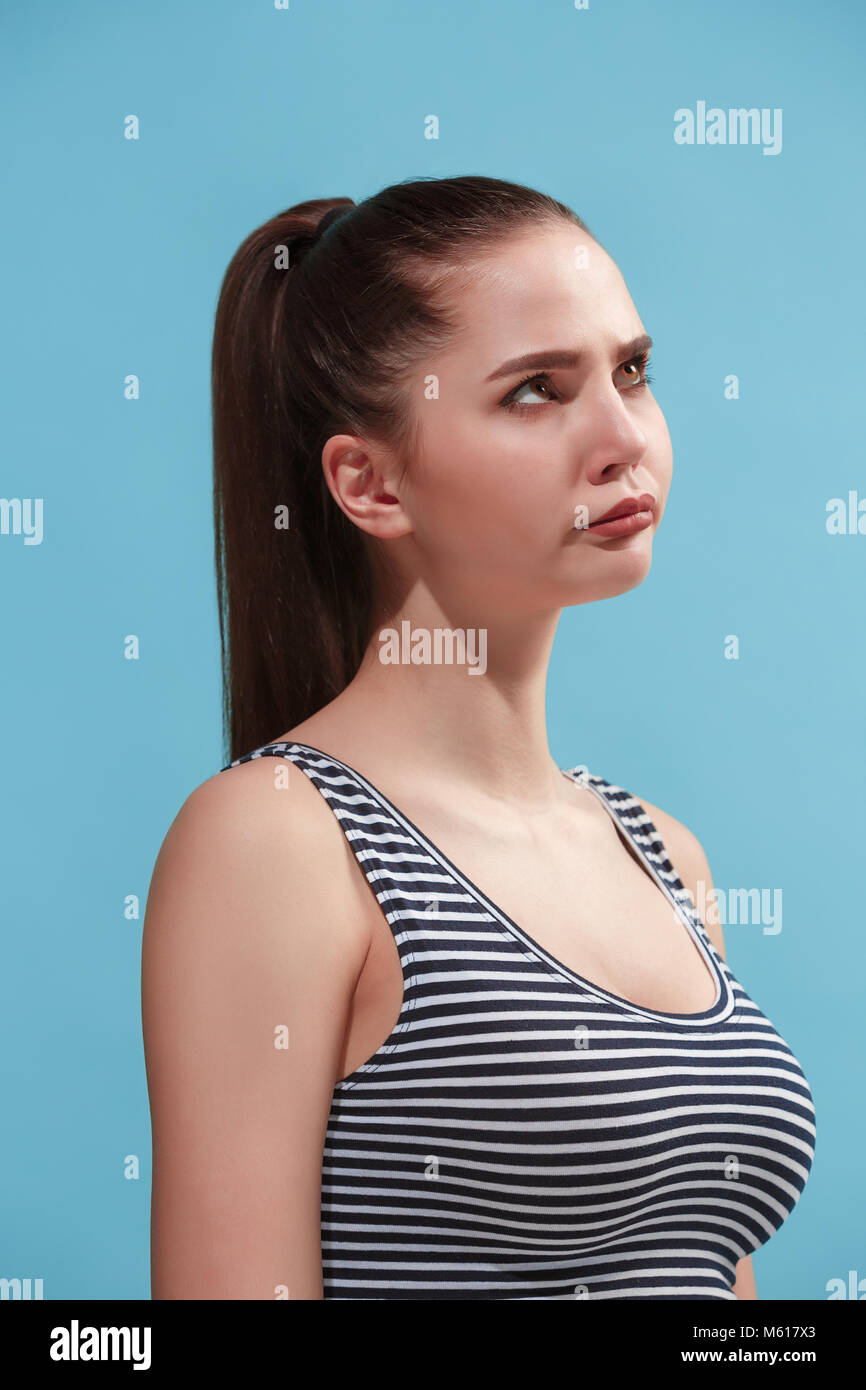 The young woman is looking boring on the blue background Stock Photo ...