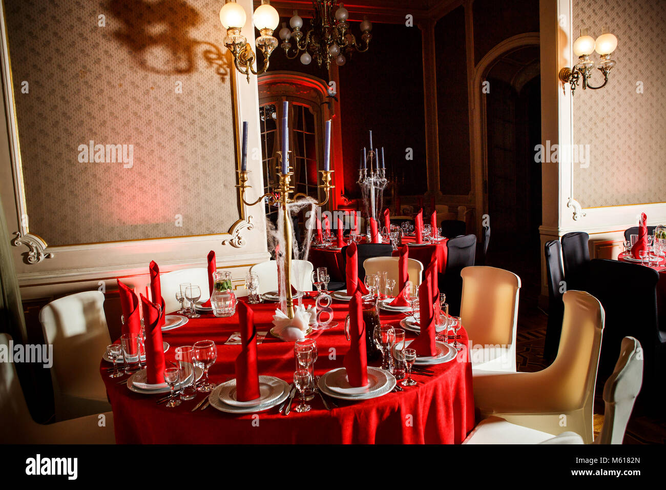 served tables in red, white and black colors with candlesticks and blue ...
