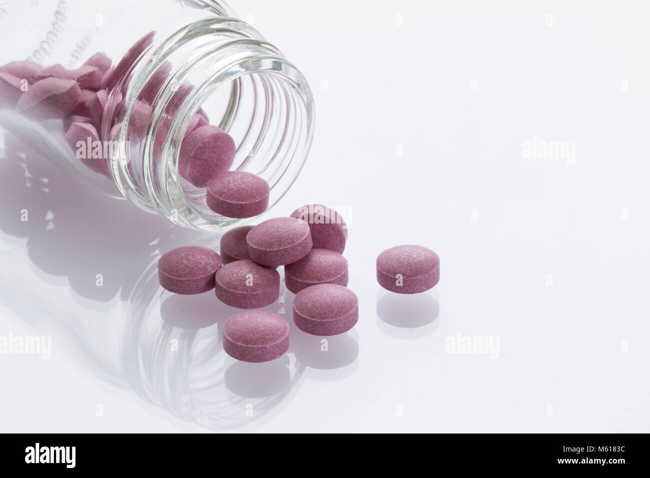 purple tablets spilled out from a glass bottle Stock Photo - Alamy