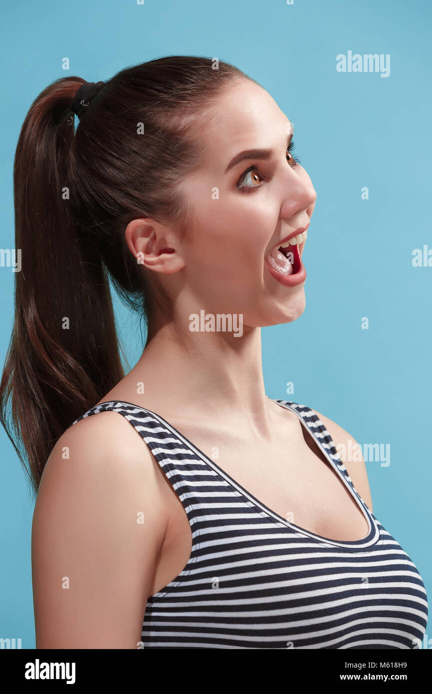 The young woman is looking crazy on the blue background Stock Photo - Alamy