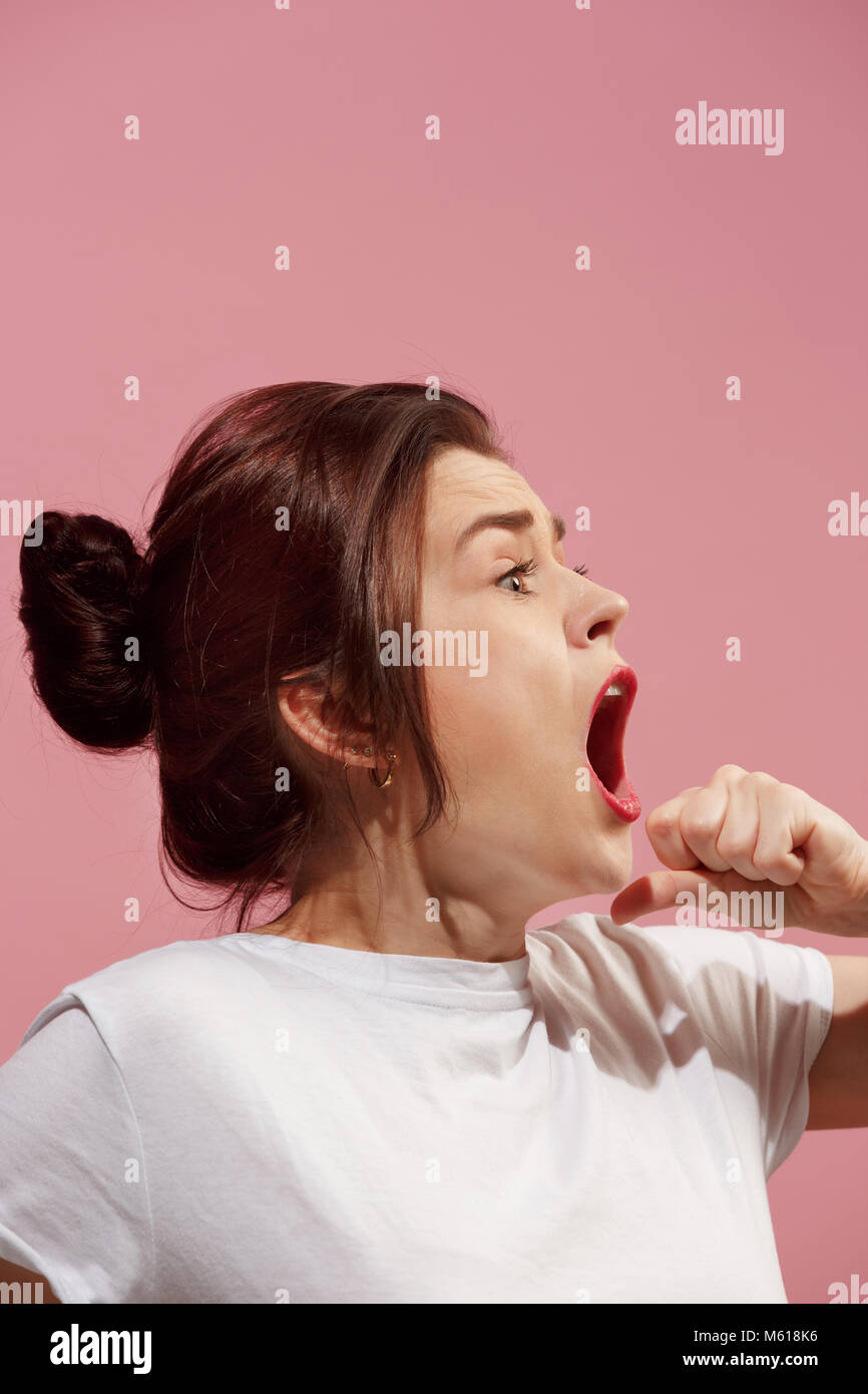 The young emotional angry woman screaming on pink studio background ...