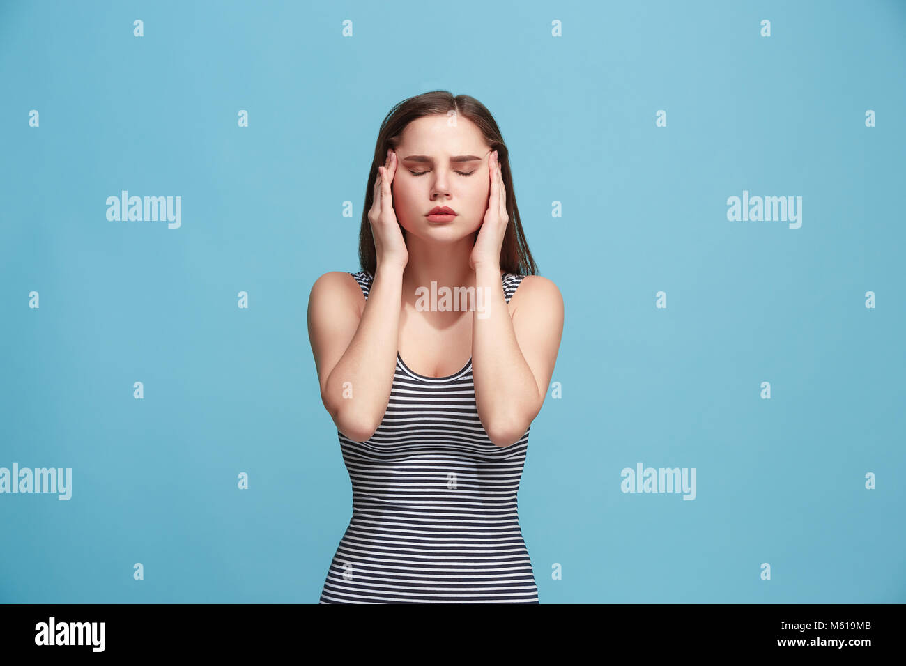 Woman having headache. Isolated over blue background Stock Photo - Alamy