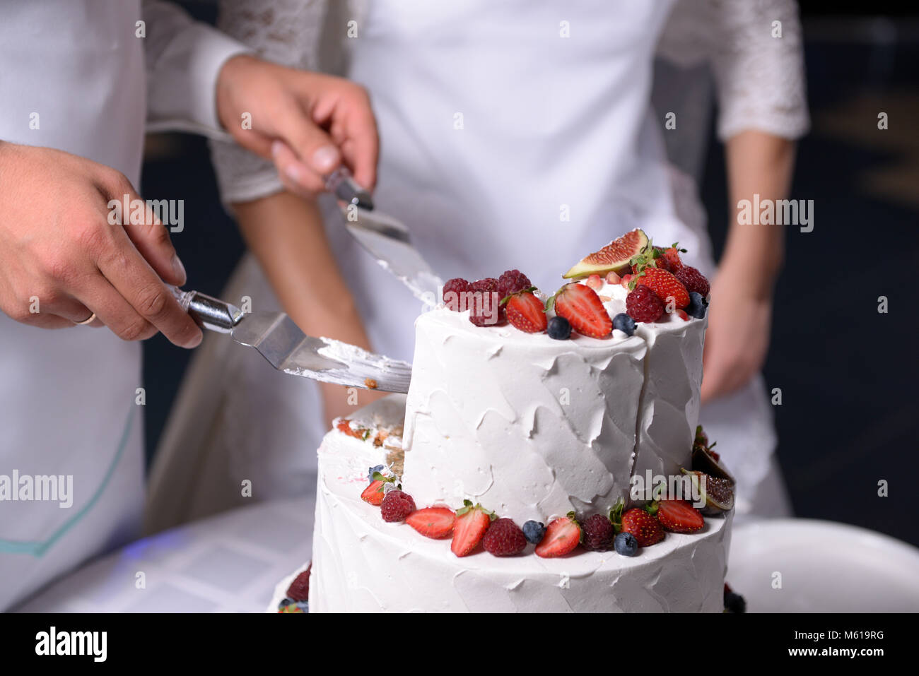 Bride and groom cut their wedding cake Stock Photo - Alamy