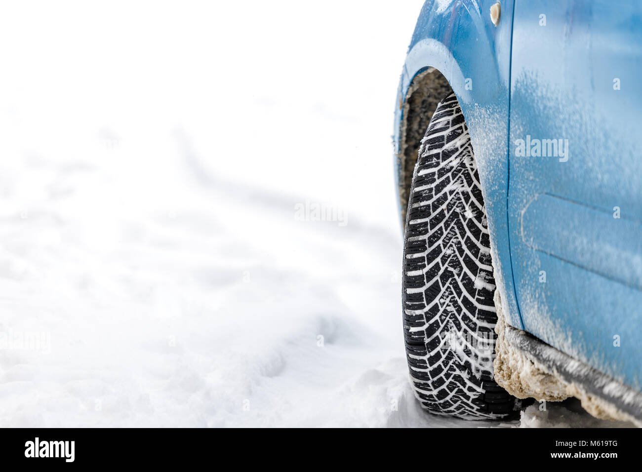 Car tyre in winter covered with snow.On road with fresh snow. close up ...