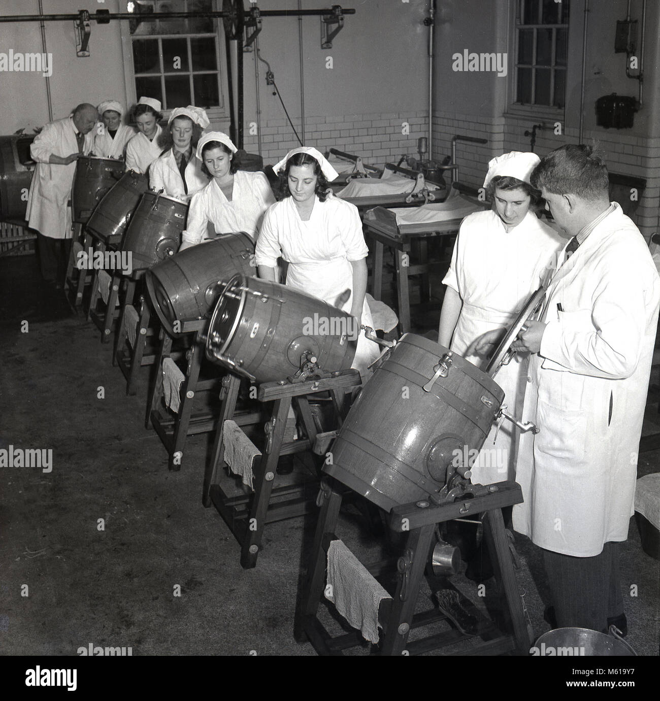 1950s, historical, male teacher at a dairy showing a group of female ...