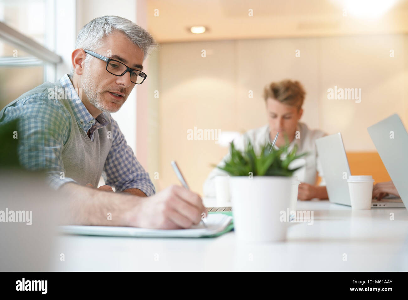 Teacher meeting around table with students Stock Photo - Alamy
