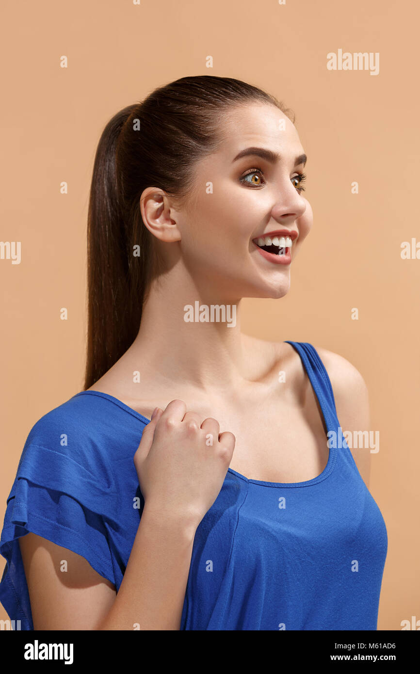 The happy woman standing and smiling against pastel background Stock ...