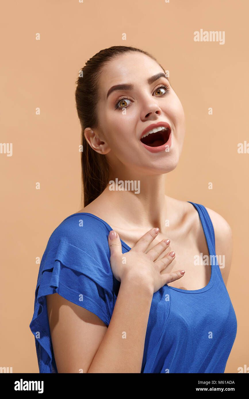 The happy woman standing and smiling against pastel background Stock ...