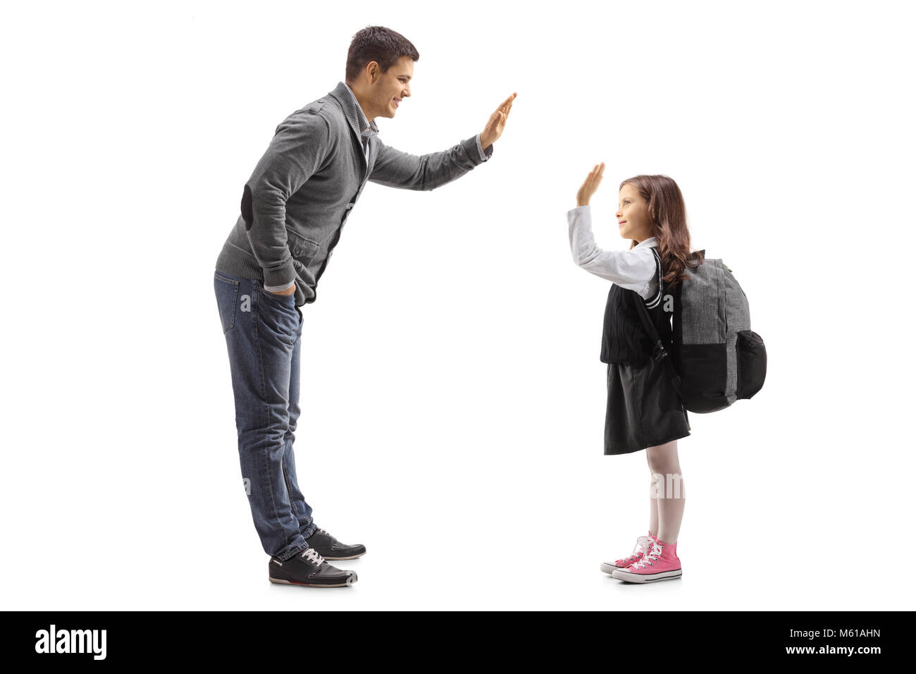 Full length profile shot of a father high-fiving his daughter isolated ...