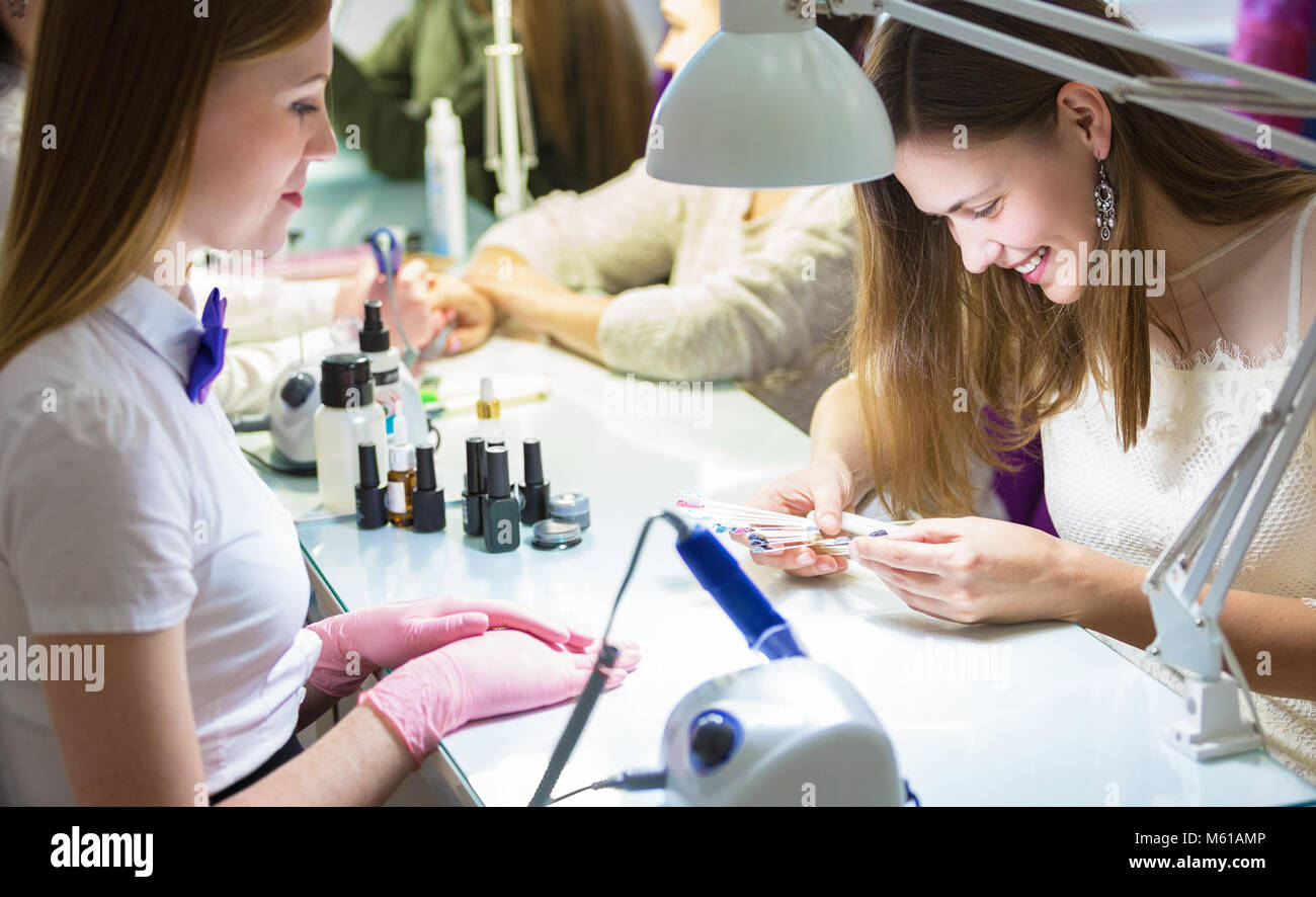Masters of manicure at work in the beauty salon. Hand care Stock Photo ...