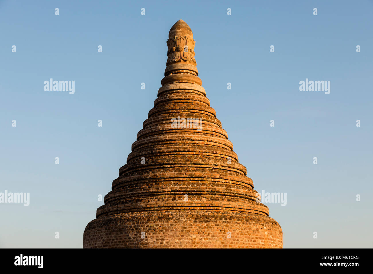 Round, stone stupa of a pagoda in the golden evening light in the ...