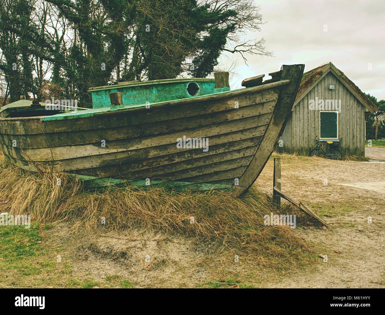 Wrecked fishing boat on old dry grass. Abandoned wooden ship with ...