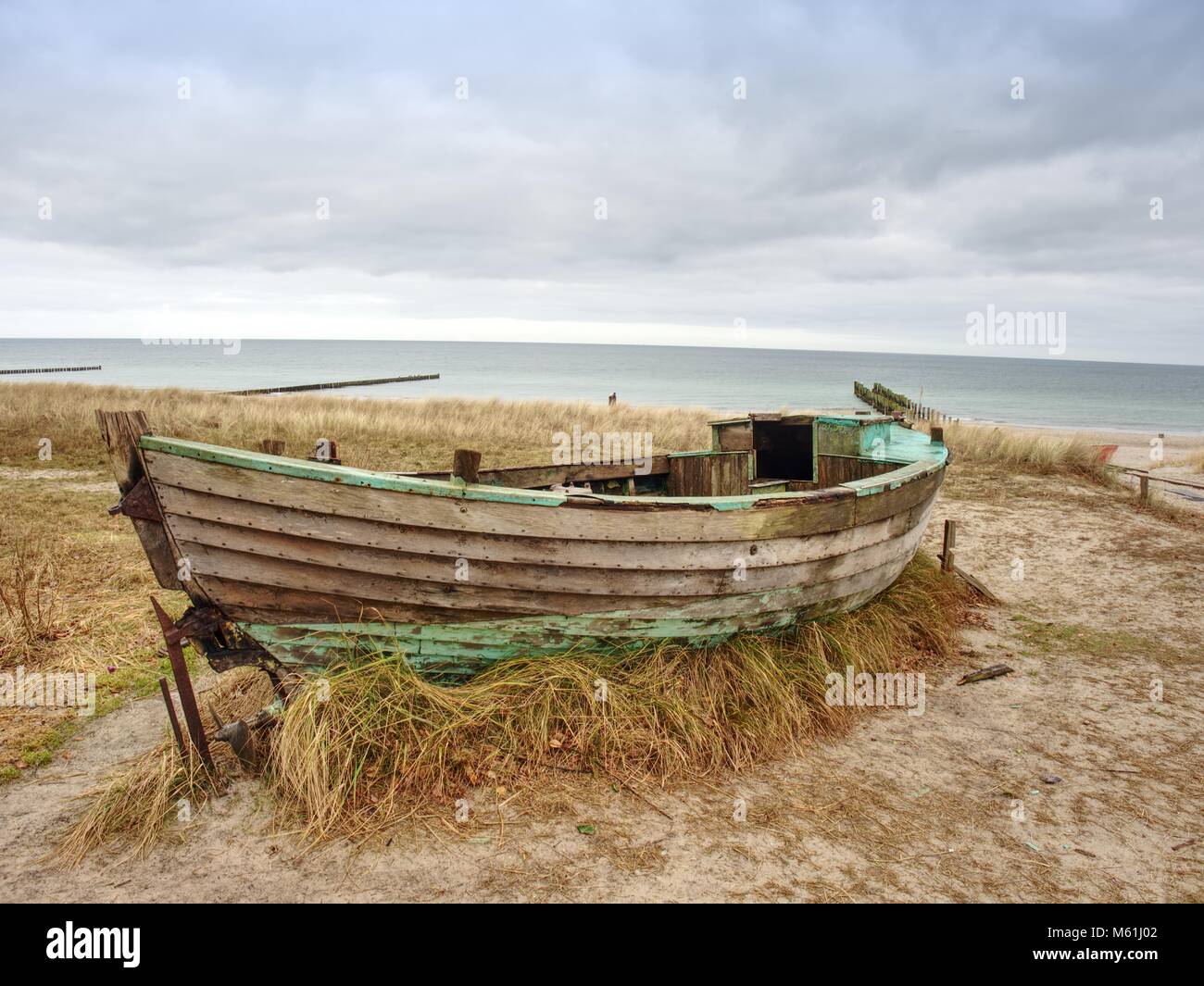 Wrecked wooden fisher boat. Broken abandoned boat in sand of sea bay ...