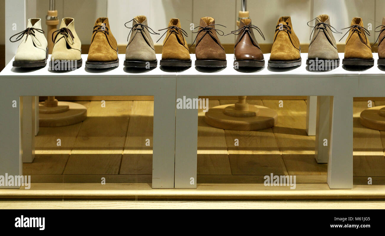Modern men shoes on shelf arranged in a row Stock Photo - Alamy