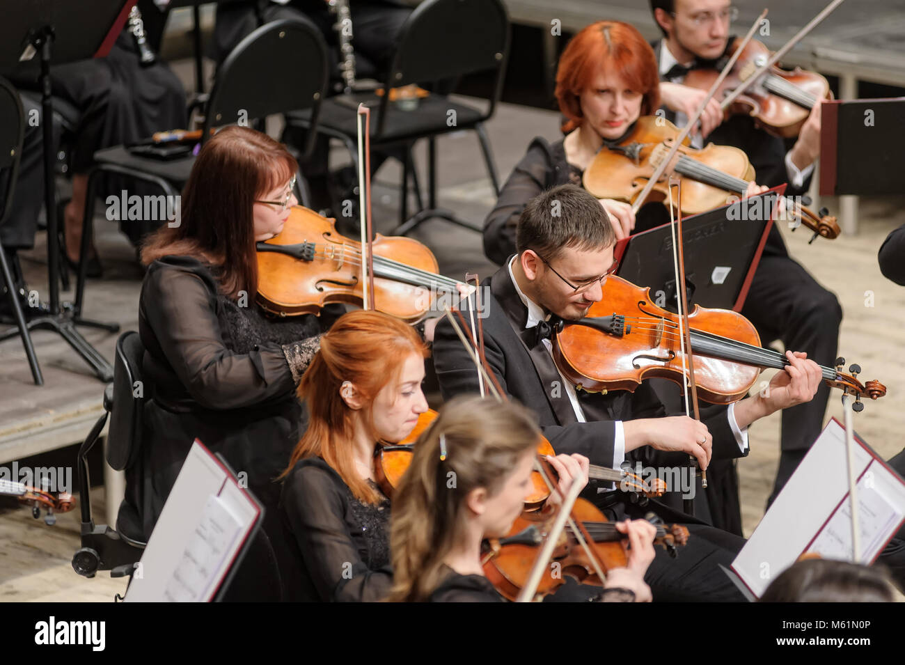 Symphony orchestra on stage. Violin group plays Stock Photo - Alamy