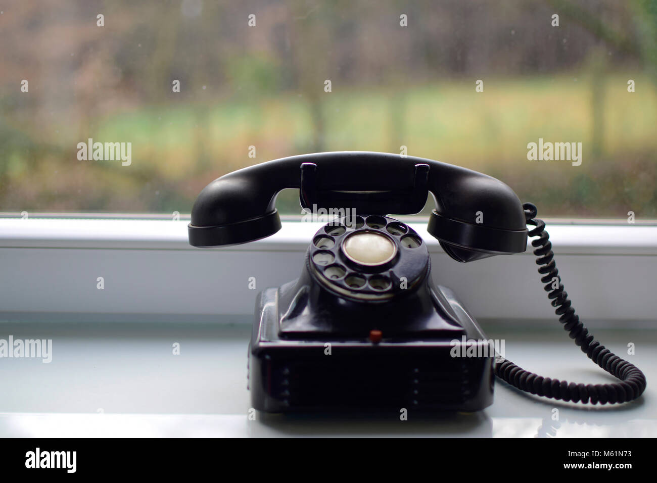 Vintage black telephone on the table near window with blurred ...