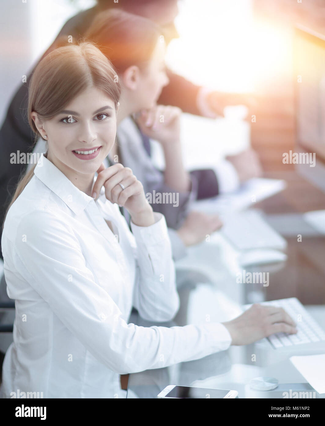 side view. young employee sitting at a Desk and looking at camera Stock ...