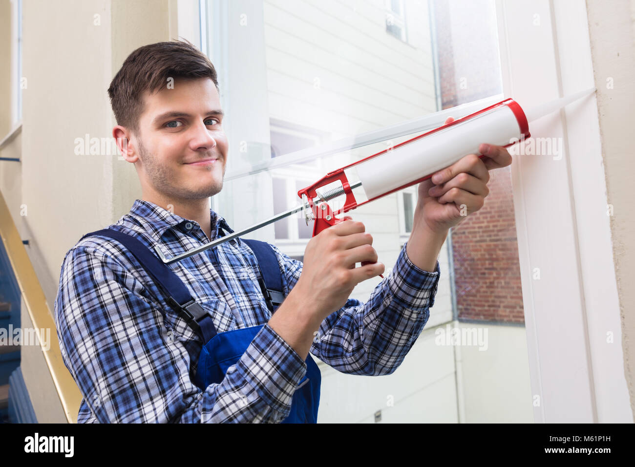 Side View Of A Young Male Worker Applying Glue With Silicone Gun Stock ...