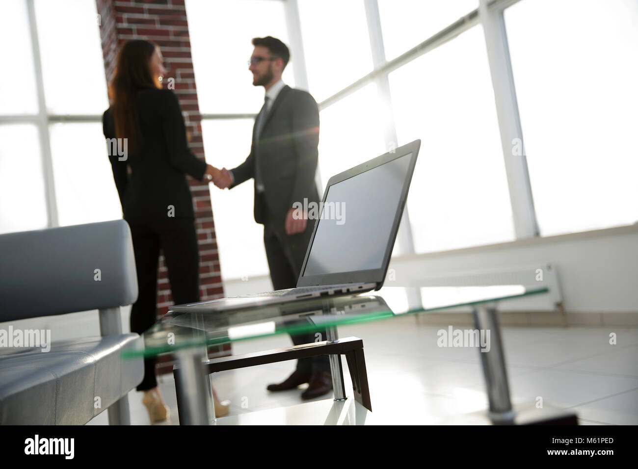 laptop on the desk, background handshake Stock Photo - Alamy