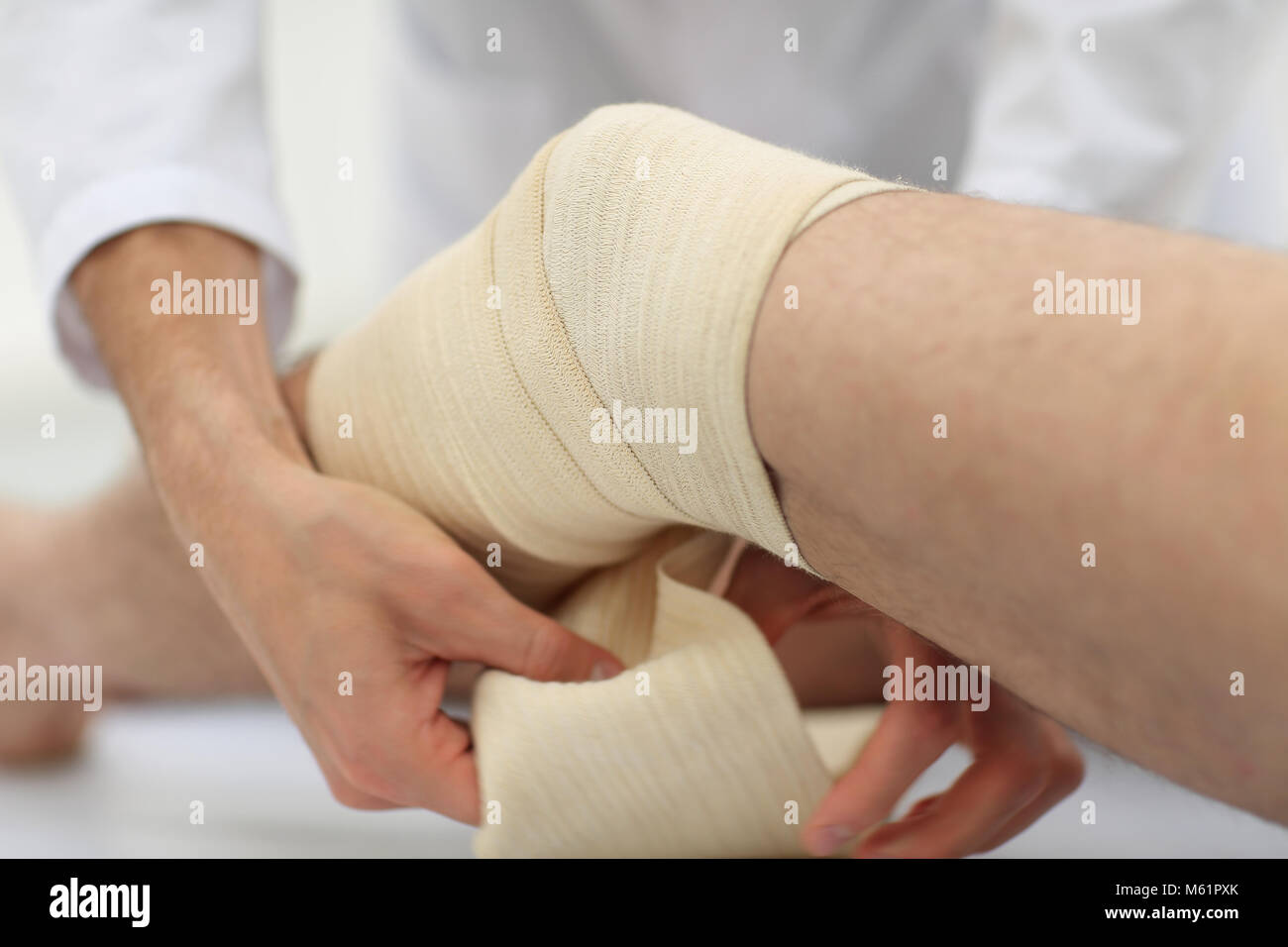 closeup. doctor bandaging a patient's leg Stock Photo - Alamy