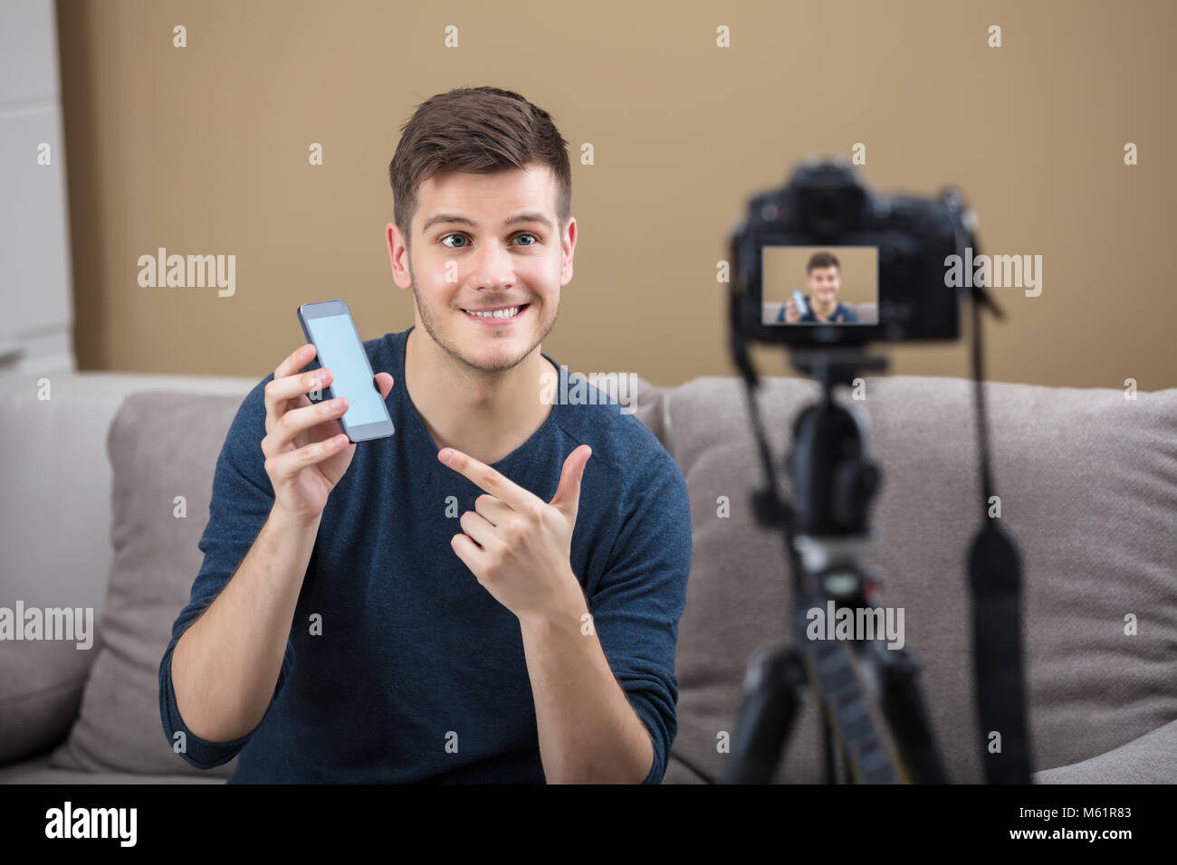 Smiling Young Male Blogger Holding Mobile Phone Recording Video With ...