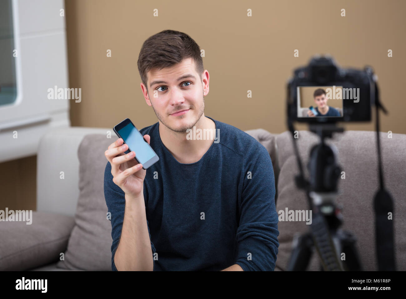 Smiling Young Male Blogger Holding Mobile Phone Recording Video With ...