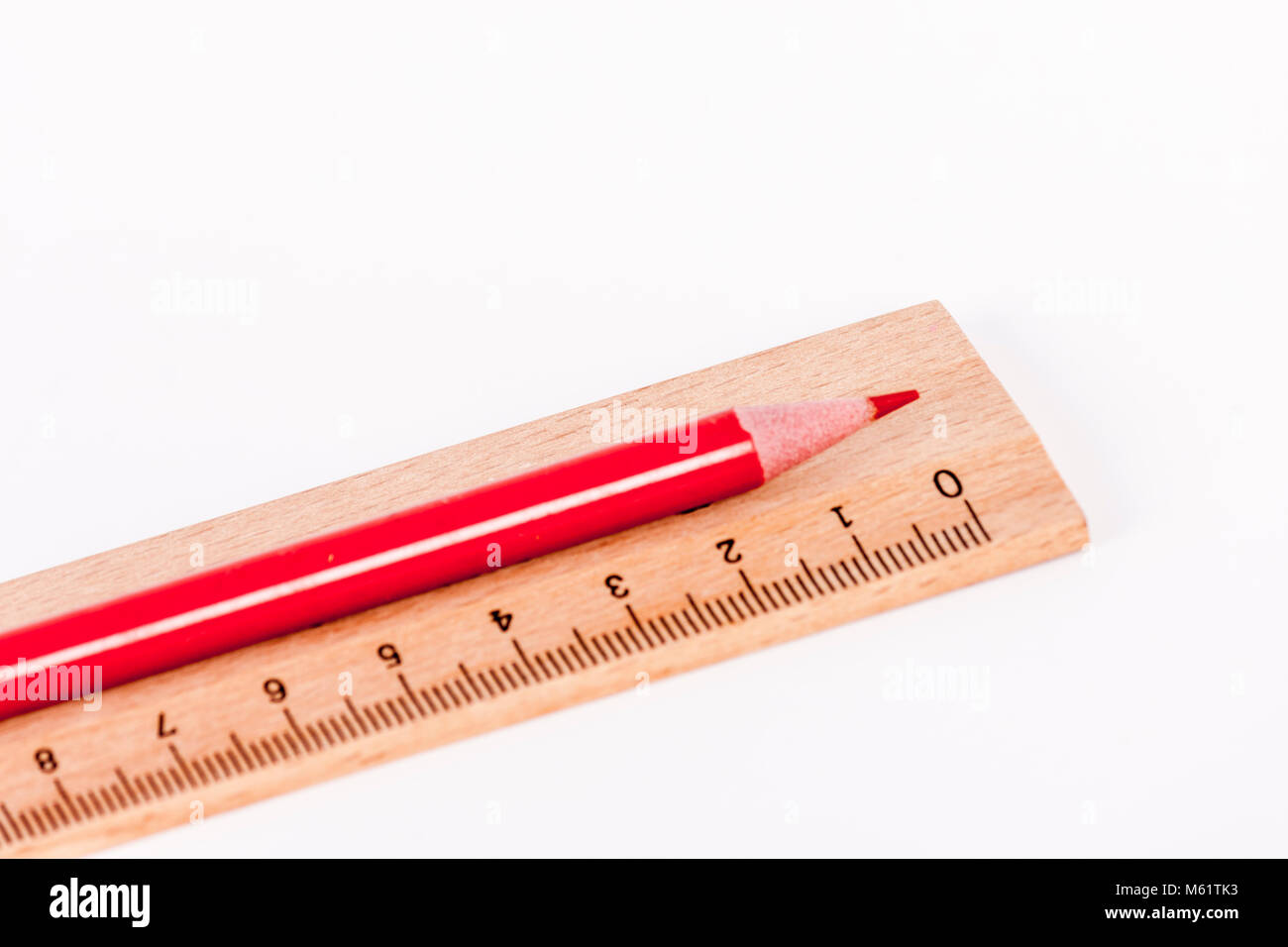 Red pencil on wooden ruler Stock Photo - Alamy