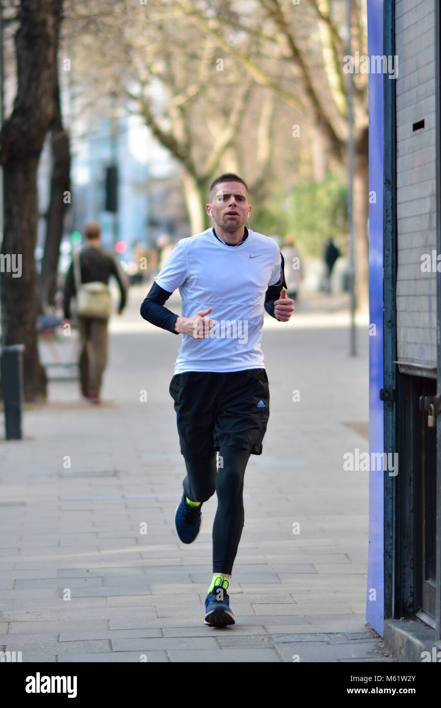 Man jogging on the pavement in London, UK Stock Photo - Alamy