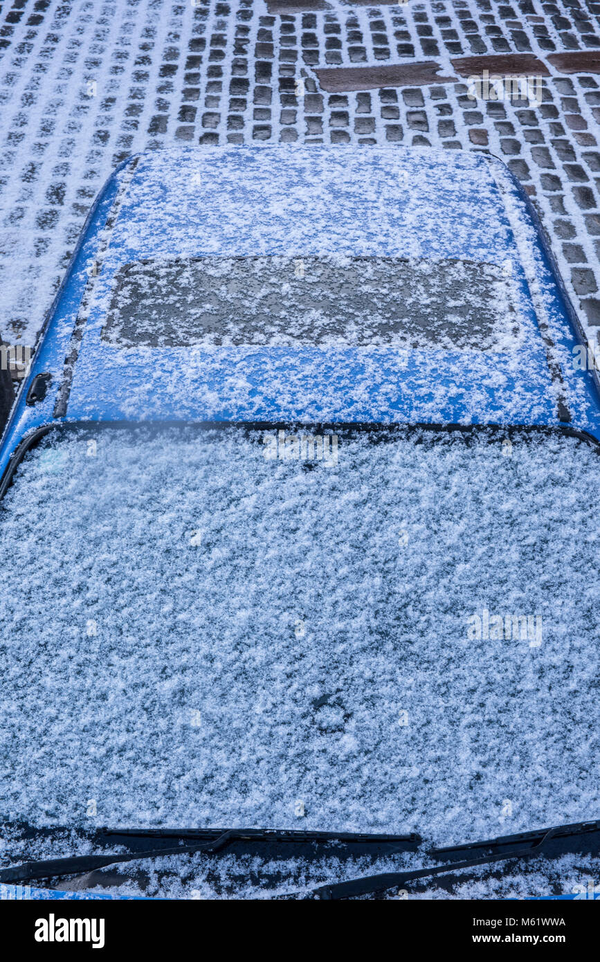 A car covered in snow and ice on a freezing morning. Defrosting the car ...