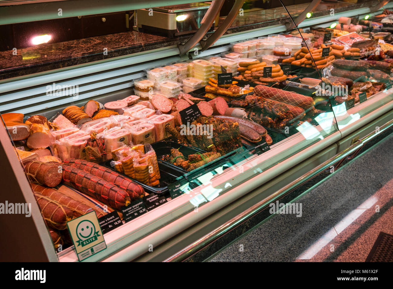 Refrigerated display with sausages and salads in the butcher shop with ...