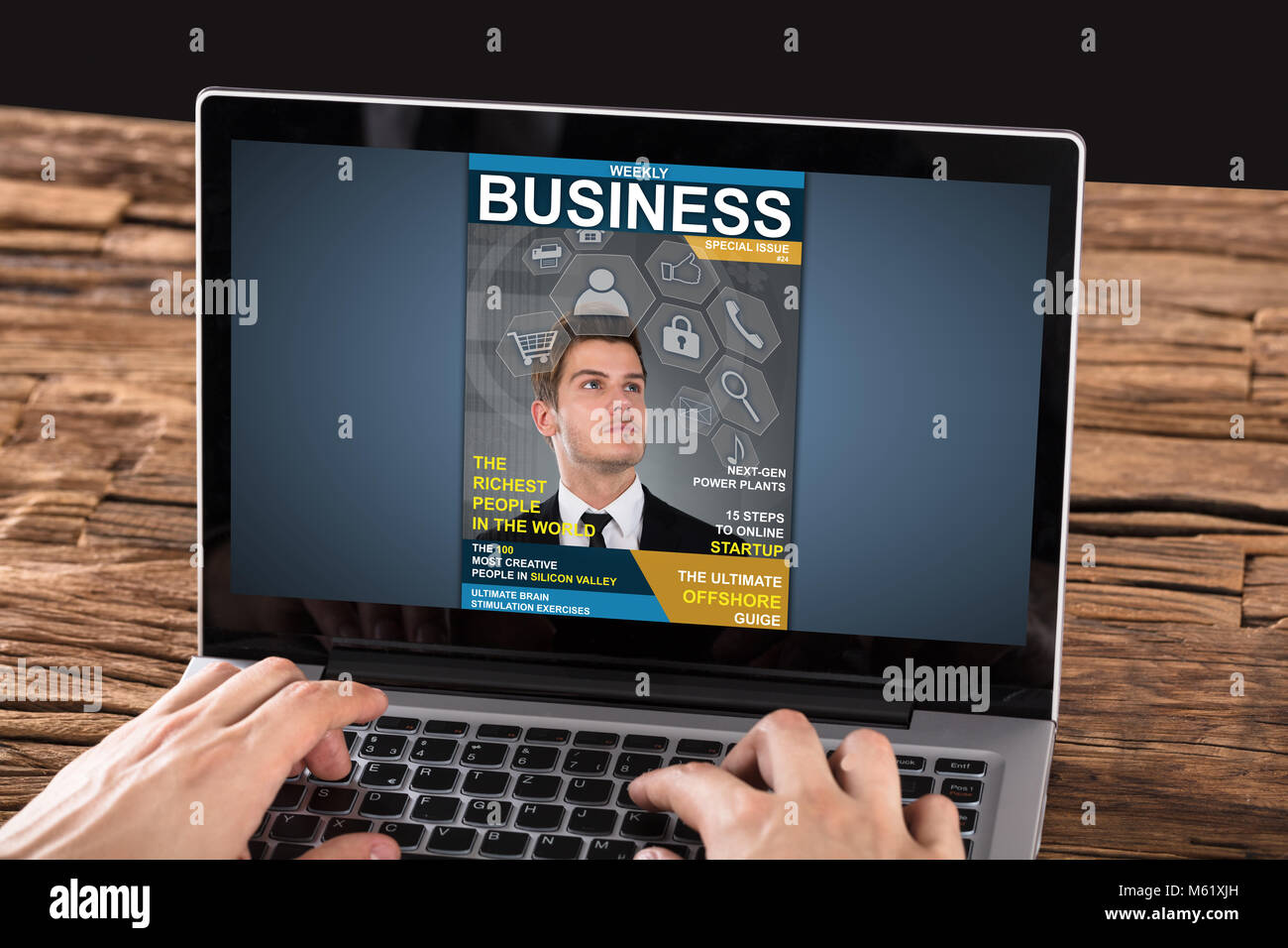 Close-up Of Person Looking At Magazine On Laptop At Desk Stock Photo ...