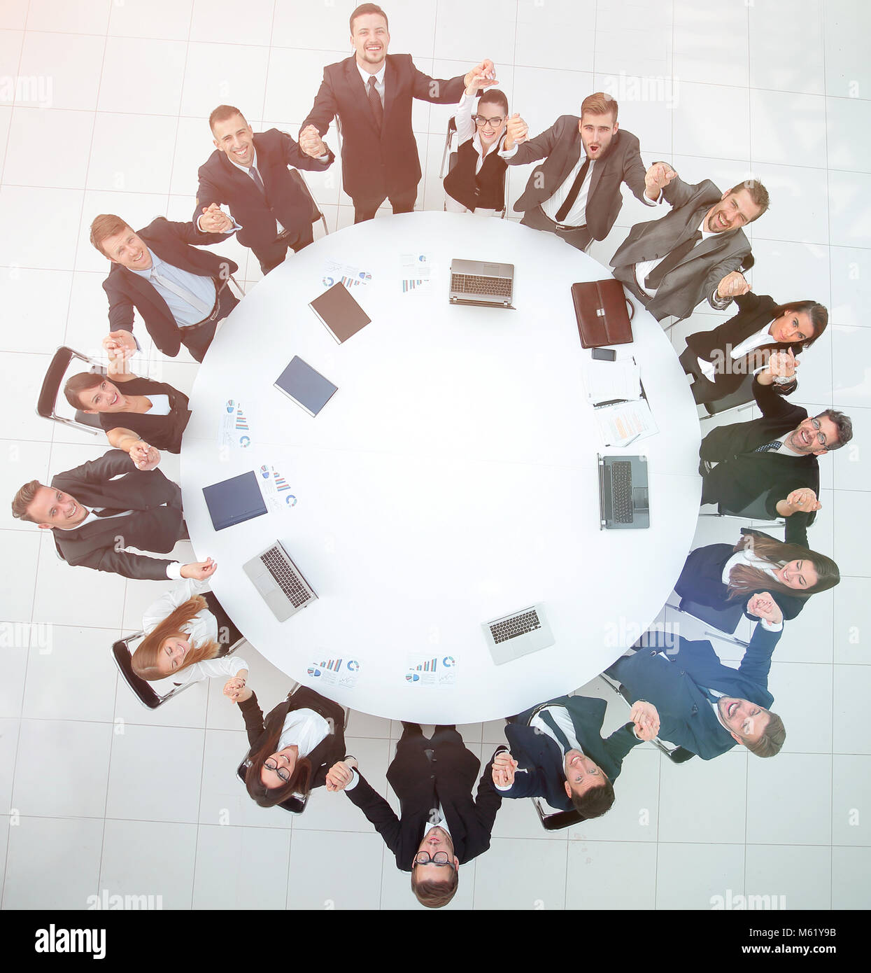 large business team sitting at the round table and raising his hands up ...