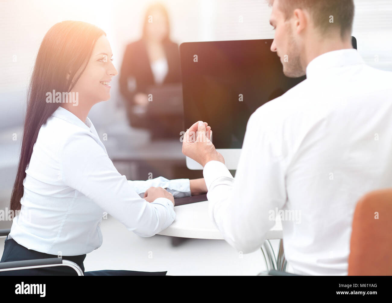 two successful employee talking sitting behind a Desk Stock Photo - Alamy