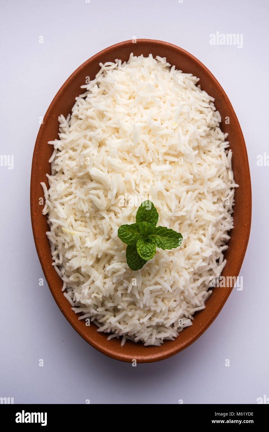 Cooked plain white basmati rice in terracotta bowl over plain or wooden ...