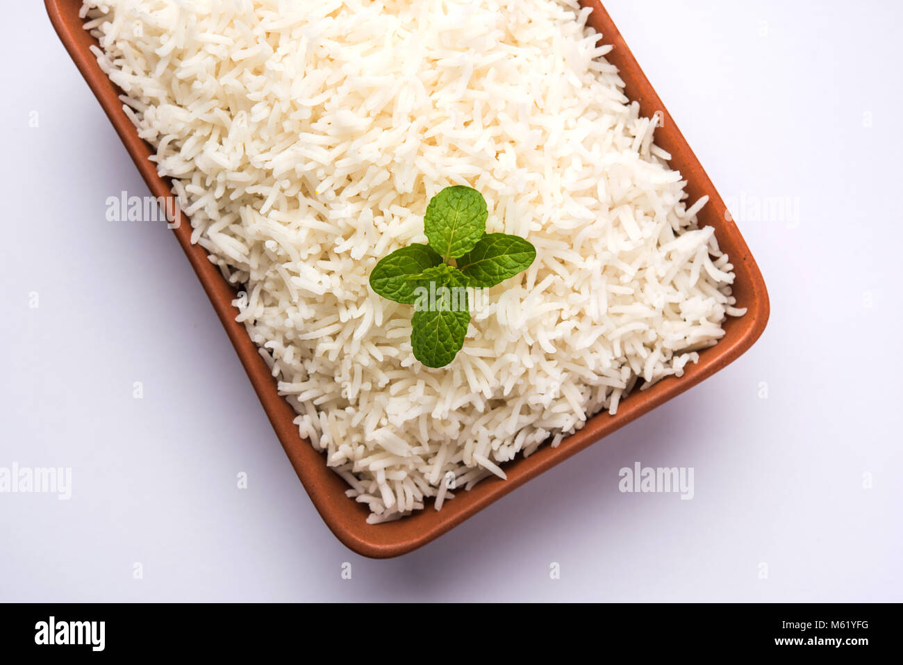 Cooked plain white basmati rice in terracotta bowl over plain or wooden ...