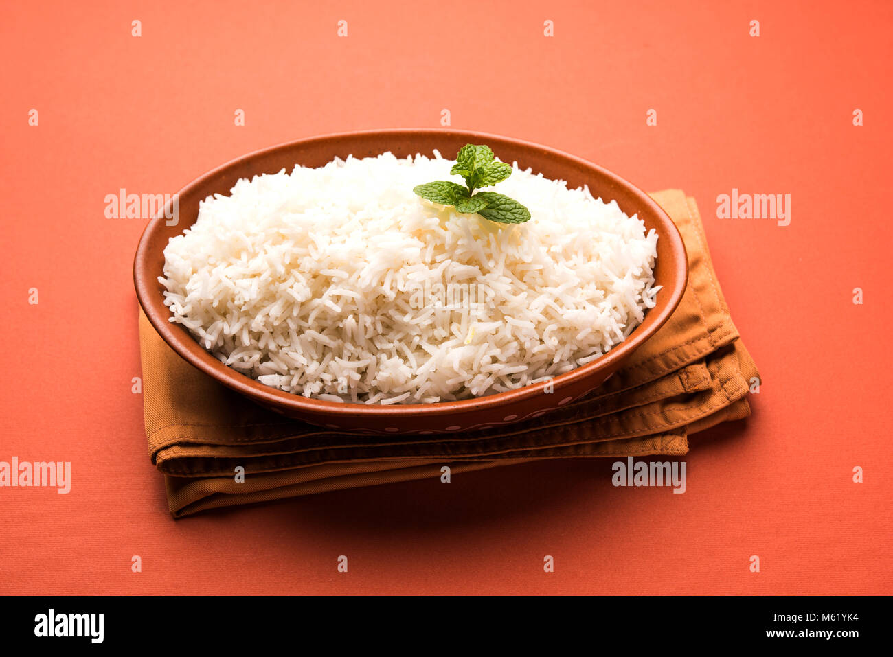 Cooked plain white basmati rice in terracotta bowl over plain or wooden ...