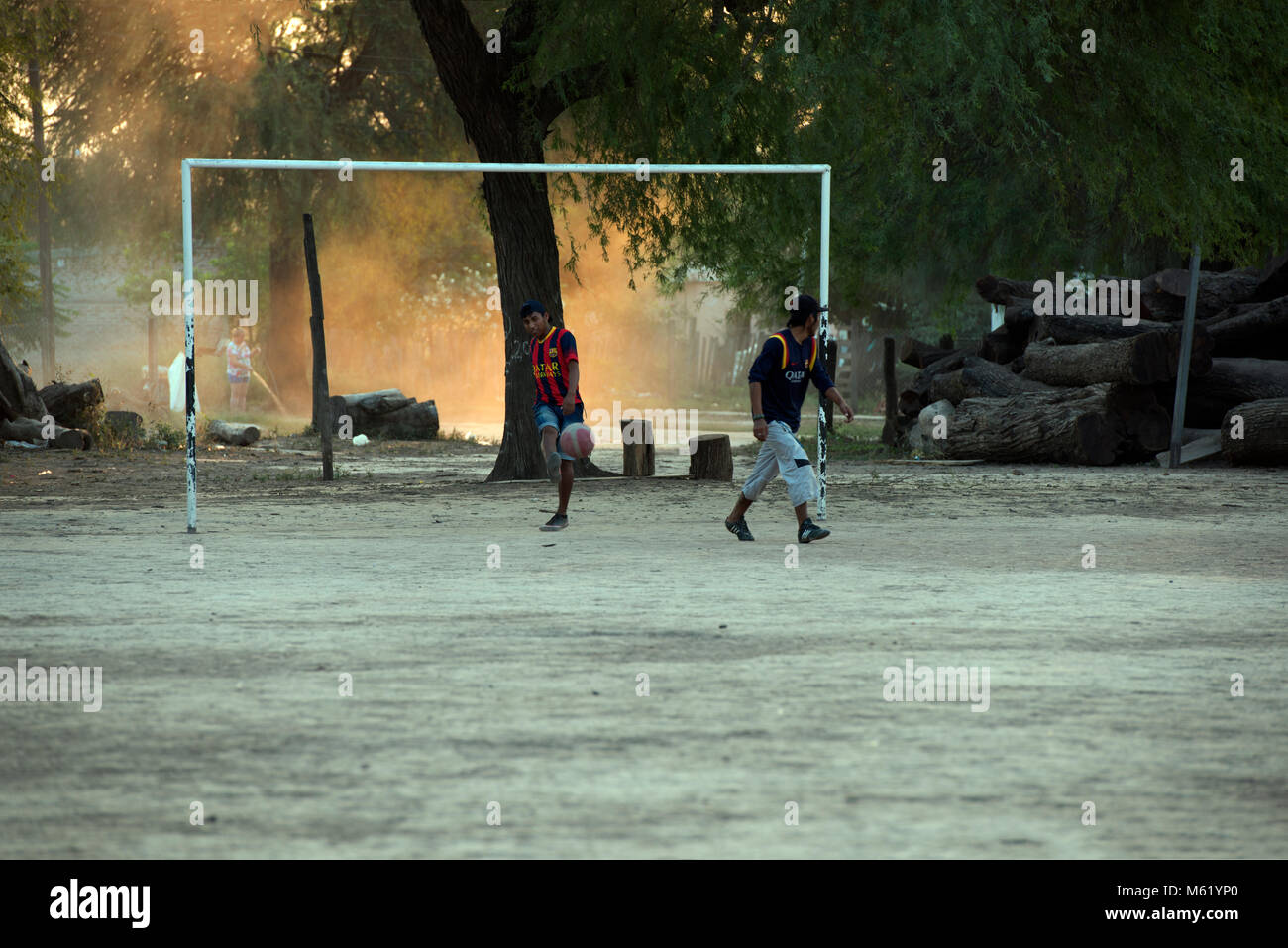 Two native Toba men playing football (soccer) in the late afternoon ...