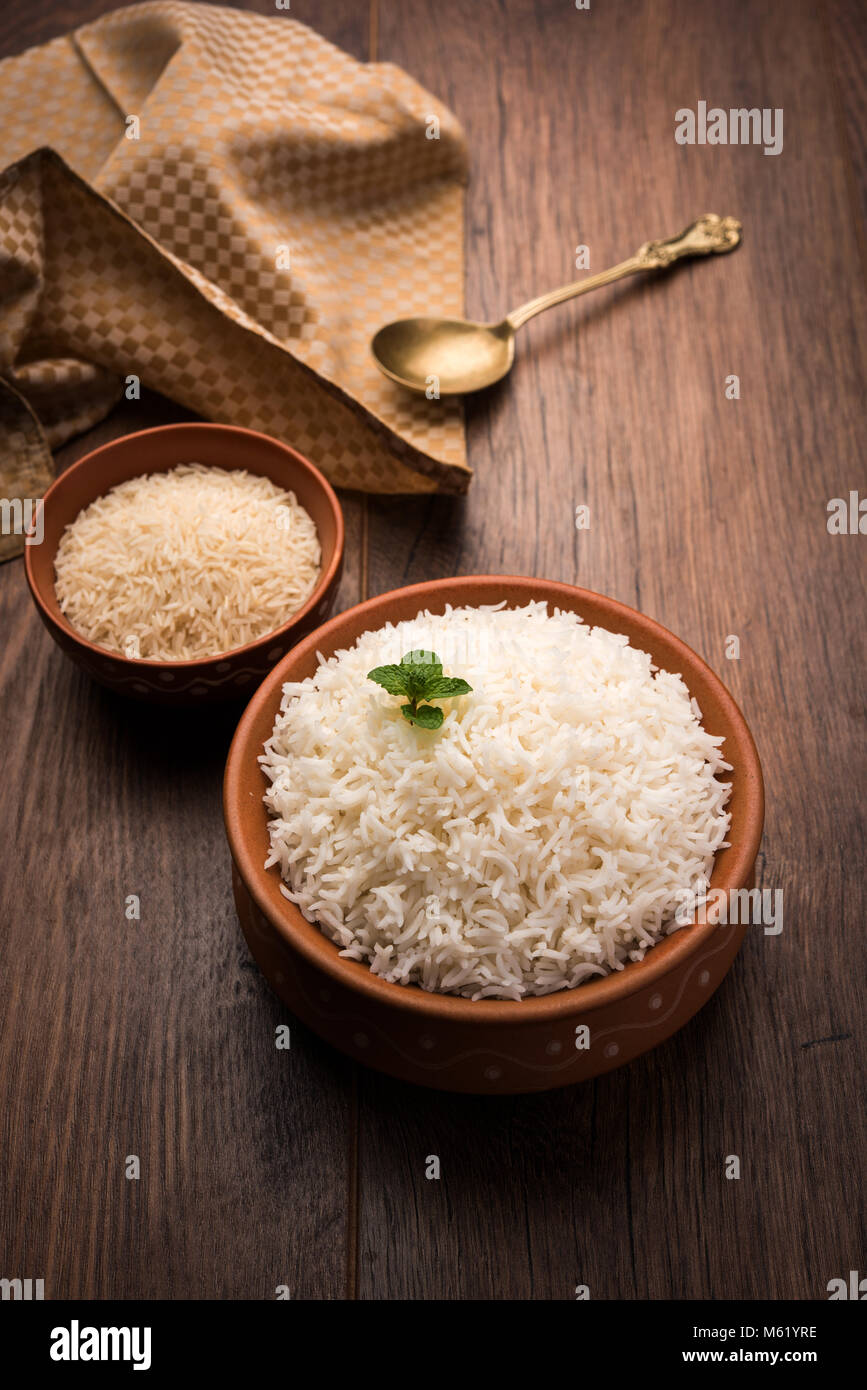 Cooked plain white basmati rice in terracotta bowl over plain or wooden ...